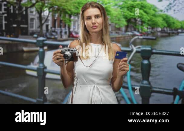 Woman holds vintage camera and creditcard on canal street bridge ...