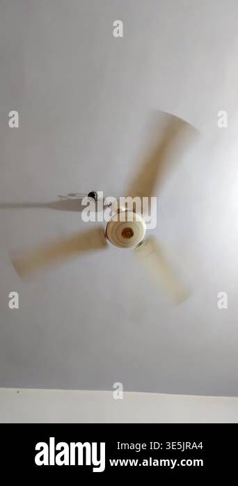Ceiling fan spinning fast in room creating cool airflow during hot ...