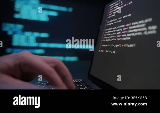 Hands of coder writing programming code on computer screen, with blue ...