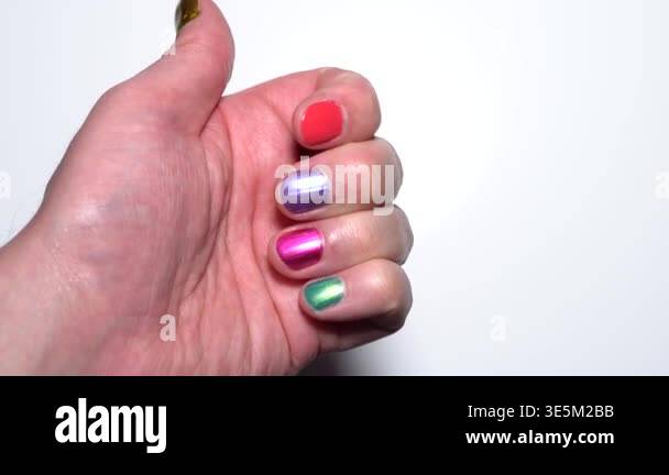 Gay and LGBT man looking at his hand nails work in rainbow colors ...