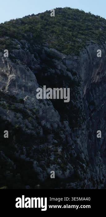 Dramatic vertical cliff face with textured rock formations in the ...