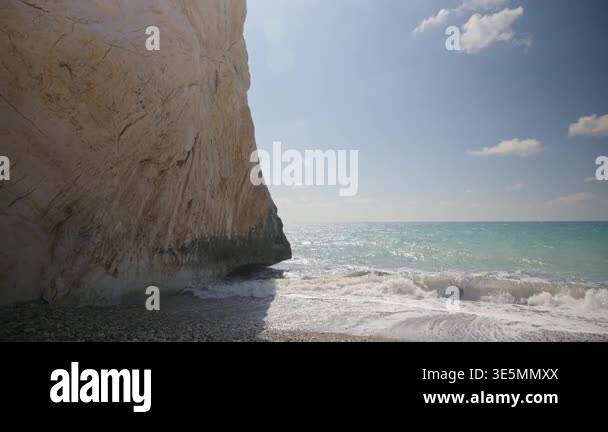 Dramatic view of a large cliff face meeting the sea at Aphrodite's Rock ...