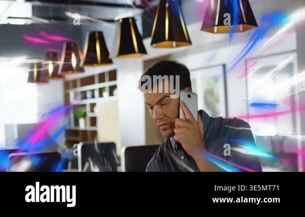 Man talking on smartphone in open-plan office, showcasing pink blue ...