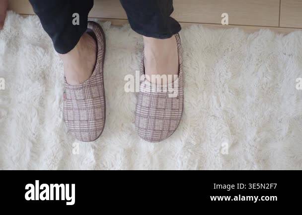 A person stands in cozy slippers on a fluffy white rug at home Stock ...