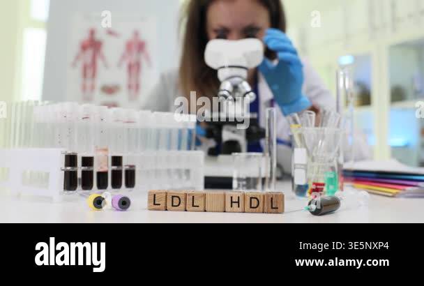 Wooden blocks spell abbreviation LDL HDL on laboratory desk. Young ...