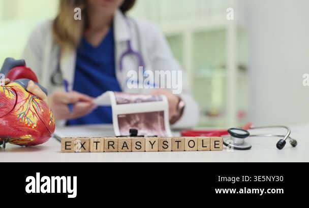 Wooden blocks spell word Extrasystole near heart model and stethoscope ...