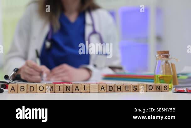 Miniature wooden cubes arranged on desk form phrase Abdominal Adhesions ...