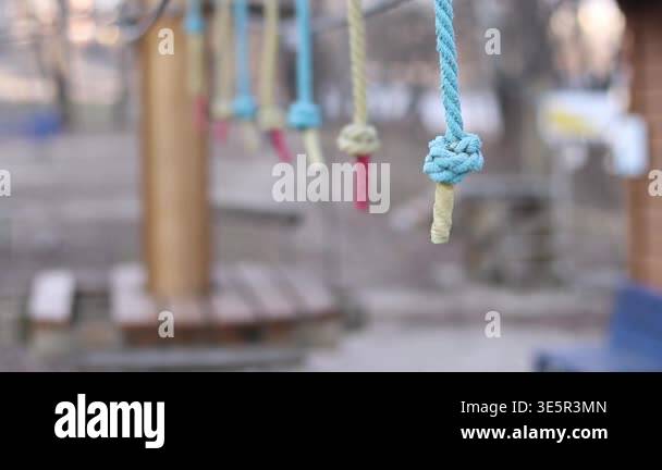 A row of vertically hanging strong ropes with securely tied knots at ...