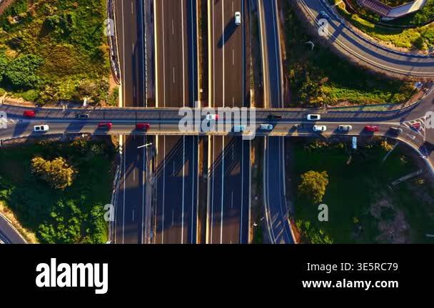 Vehicles drive along multiple lanes on highways in a busy urban setting ...