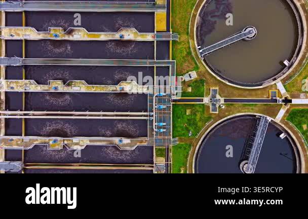Workers are managing various tanks at a wastewater treatment plant. The ...