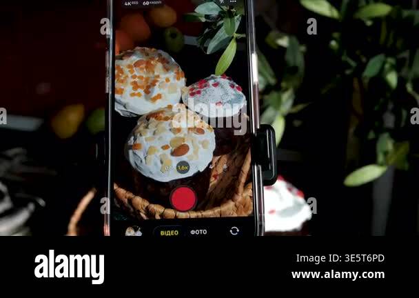 Female hands arrange and tear Easter breads while recording on a mobile ...