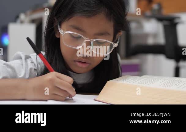 Stressed little Asian girl with glasses crying while studying, unhappy ...