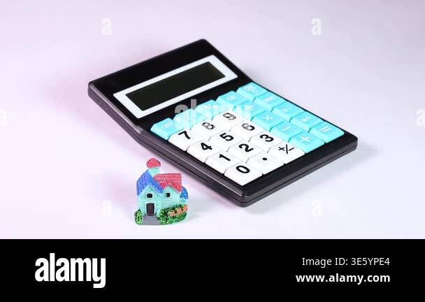 Miniature house and calculator rotating on white background Stock Video ...