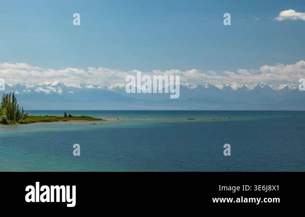 White clouds drift across the blue sky above the turquoise waters of ...