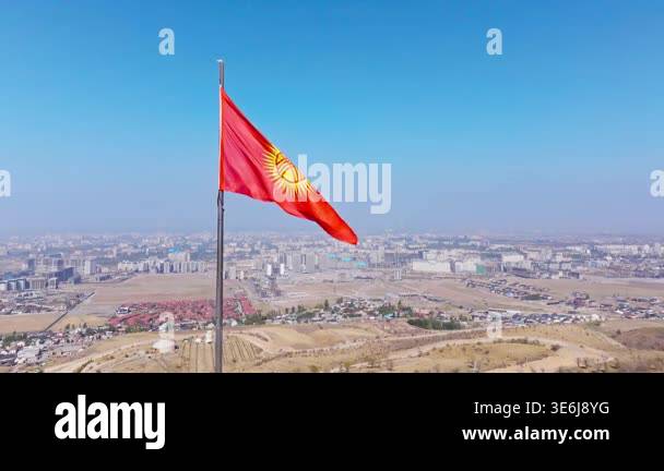 National Flag of Kyrgyzstan swaying in front of Bishkek city. Capital ...