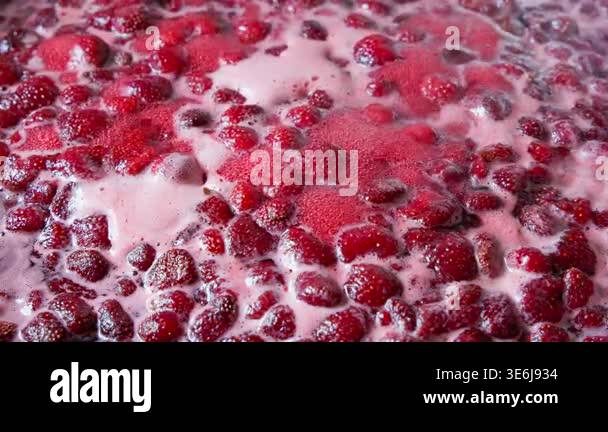 Whole and halved strawberries submerged in frothy pink liquid create a ...