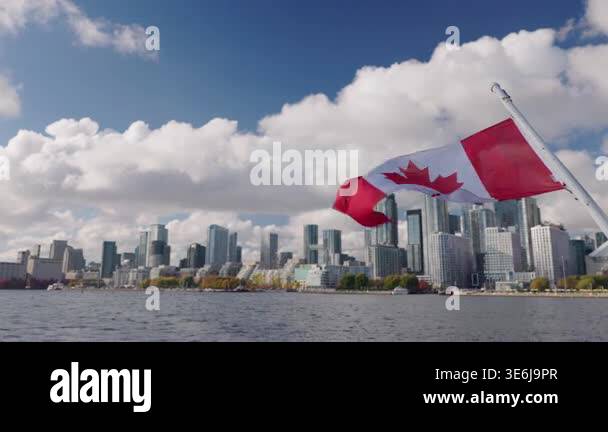 Canadian flag waving on boat with Toronto skyline in background ...