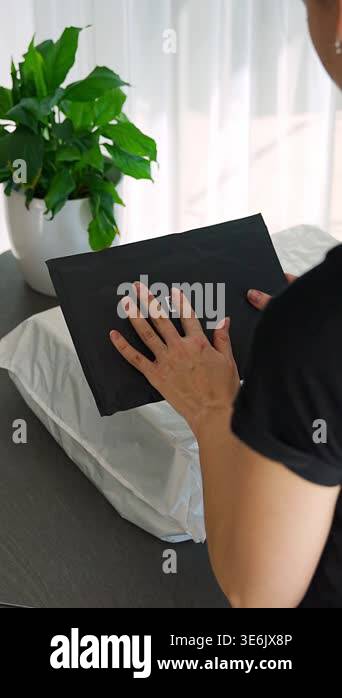 Person holding small parcel with compact QR code label compared to ...