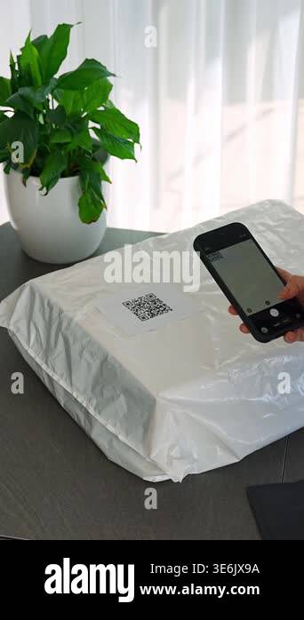 Person scanning QR code on parcel with smartphone camera for delivery ...