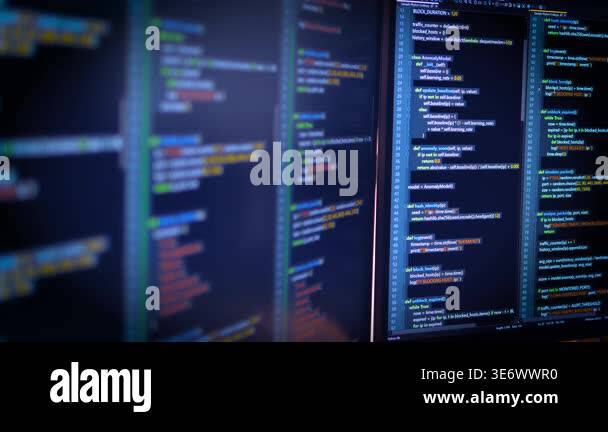 Close up computer monitors displaying fictional programming code and ...
