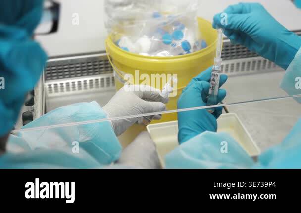 Close up of laboratory technicians handling sample tubes and pipette in ...