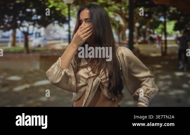 Young hispanic woman with hand to mouth and both hands on forehead on ...