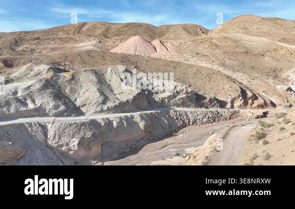 Aerial fly through of winding desert road and dramatic rock formations ...