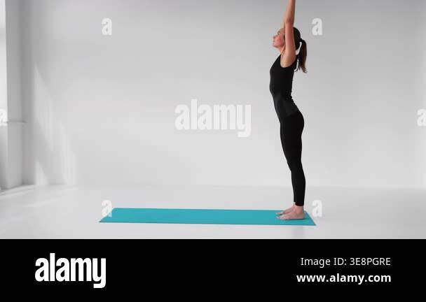 Young flexible woman practicing sun salutation complex, vinyasa yoga ...