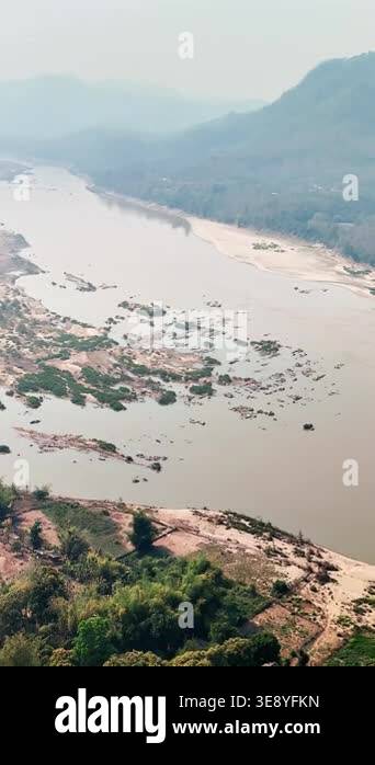 Aerial drone view of the Mekong River flowing through mountains and ...