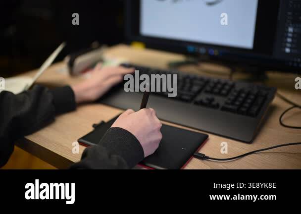 Person using graphic tablet connected to computer for digital design ...