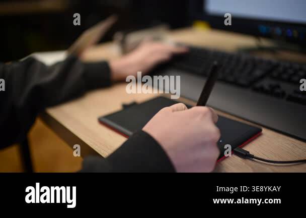 Person using graphic tablet connected to computer for digital design ...
