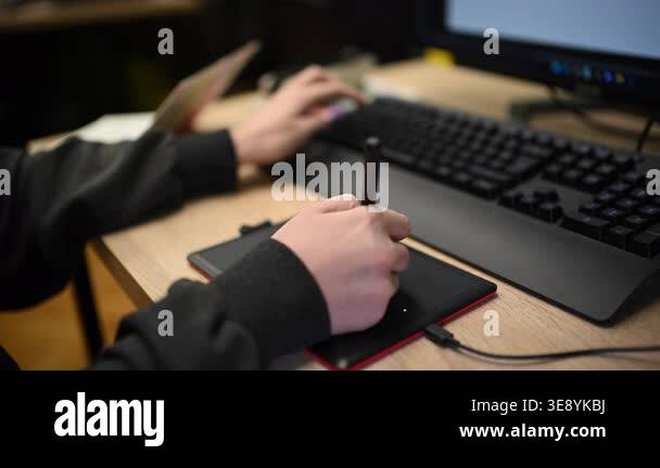 Person using graphic tablet connected to computer for digital design ...