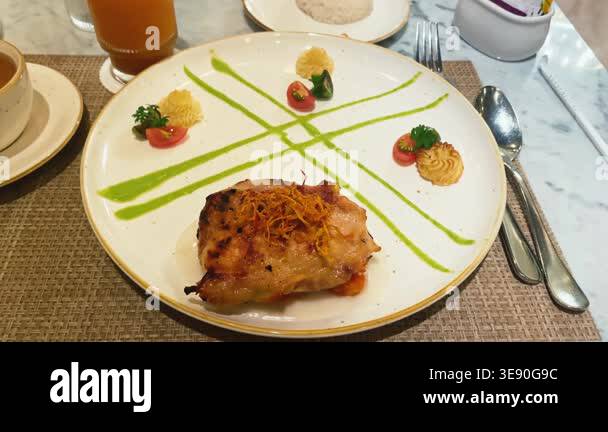 A beautifully plated gourmet chicken dish is presented on a white plate ...