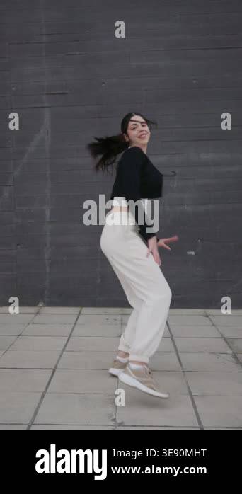 Young woman performing a energetic afrobeat and hip hop dance ...