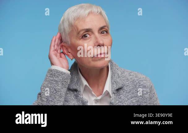 Portrait of a mature woman cupping her ear and listening closely ...
