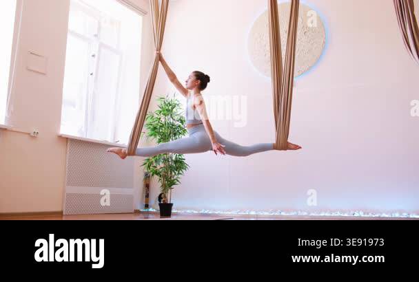 Gymnastics balance. Stretching exercise. Young female doing fly yoga ...
