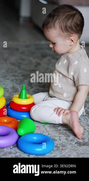 One year old toddler disassembling the toy pyramids. Little baby boy ...