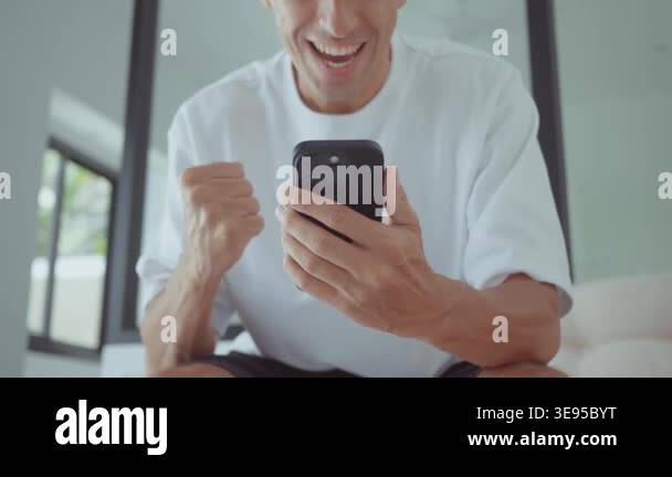 happy man checking smartphone smiling after successful online ...