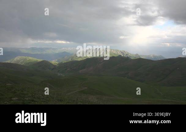 Treeless mountain valleys timelapse with sun rays breaking through ...