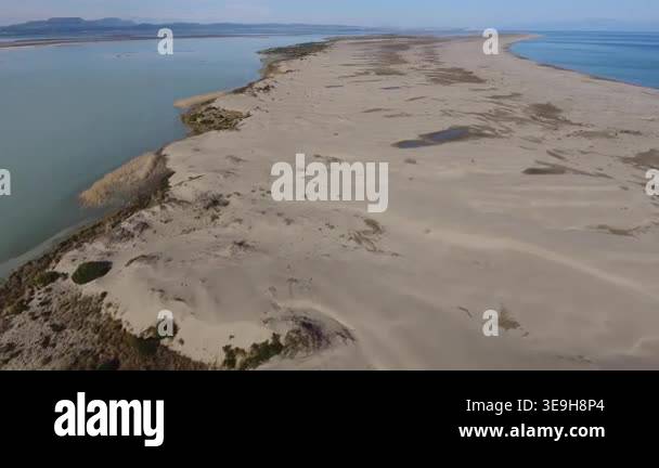 Aerial view shows sand barrier between sea and coastal lagoon beneath ...
