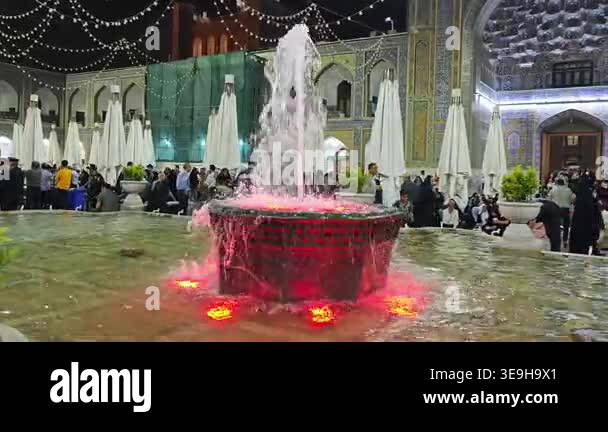 Night courtyard of Goharshad Mosque with fountain, pilgrims, and black ...