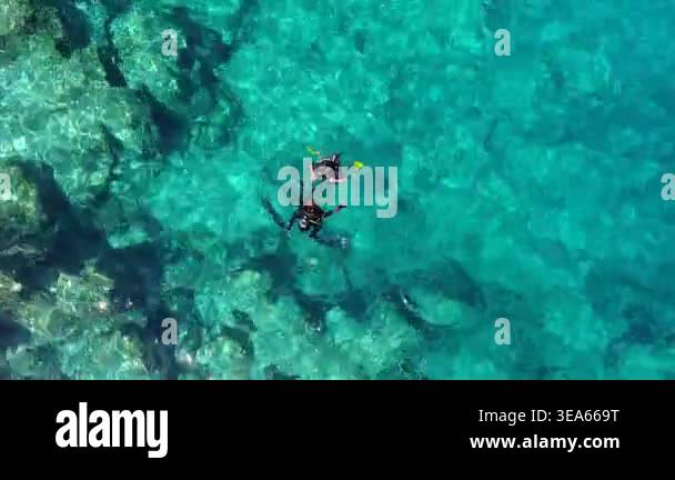 Aerial scuba diving training above rocky reef shows students and ...
