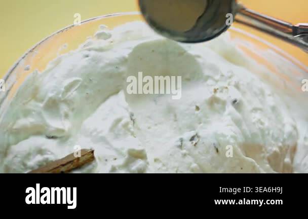 Scooping a ball of homemade custard ice cream with an ice cream scoop ...