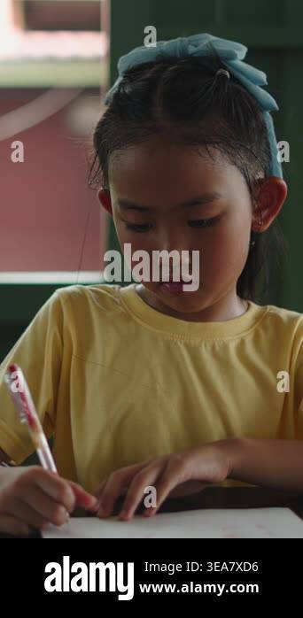 Cute little elementary school girl concentrating while doing her ...