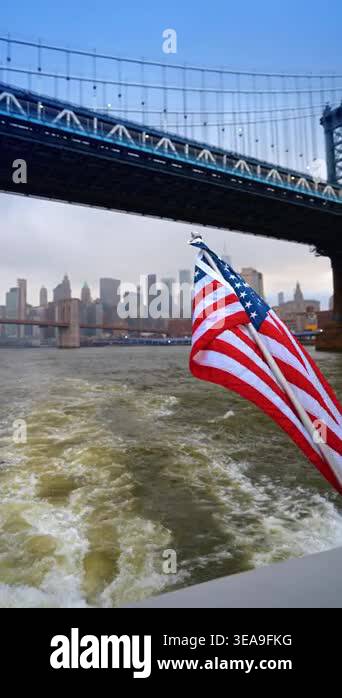 American flag waving on boat near Manhattan Bridge NYC. United States ...