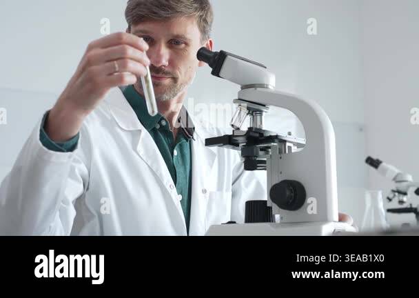 Adult male medical researcher analyzing samples with an advanced ...