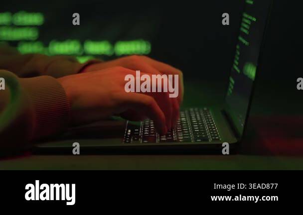 Close up of hacker hands opening a laptop and typing in dark ...