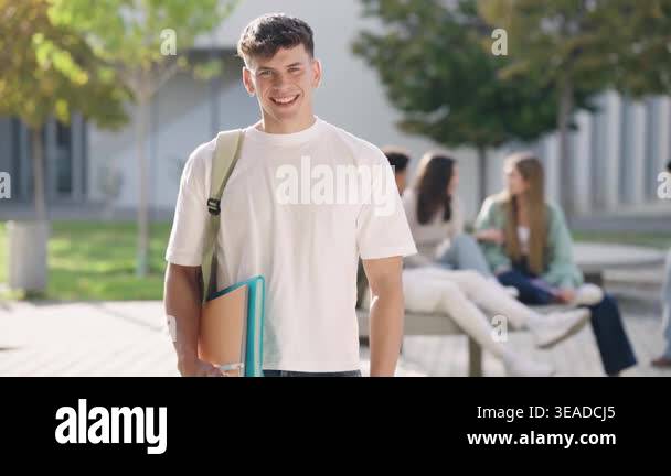 Handsome male student with a backpack and books walking in the ...