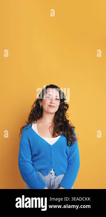 Beautiful young woman with long curly hair looking at the camera and ...