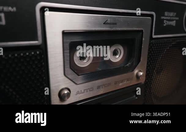A vintage audio cassette tape rests inside the playback mechanism of a ...